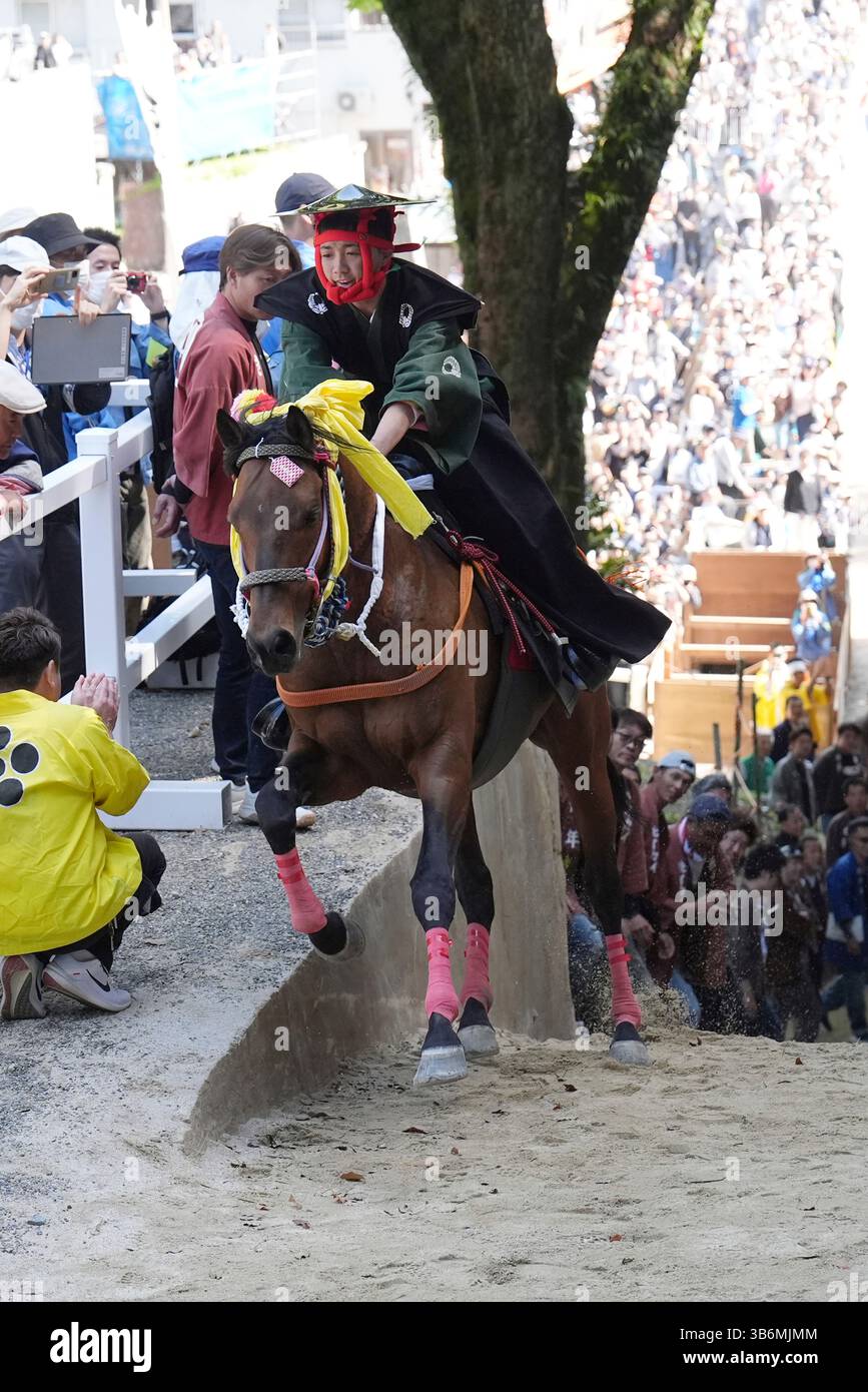 A horse carrying a young man dressed as a warrior runs up a slope ...