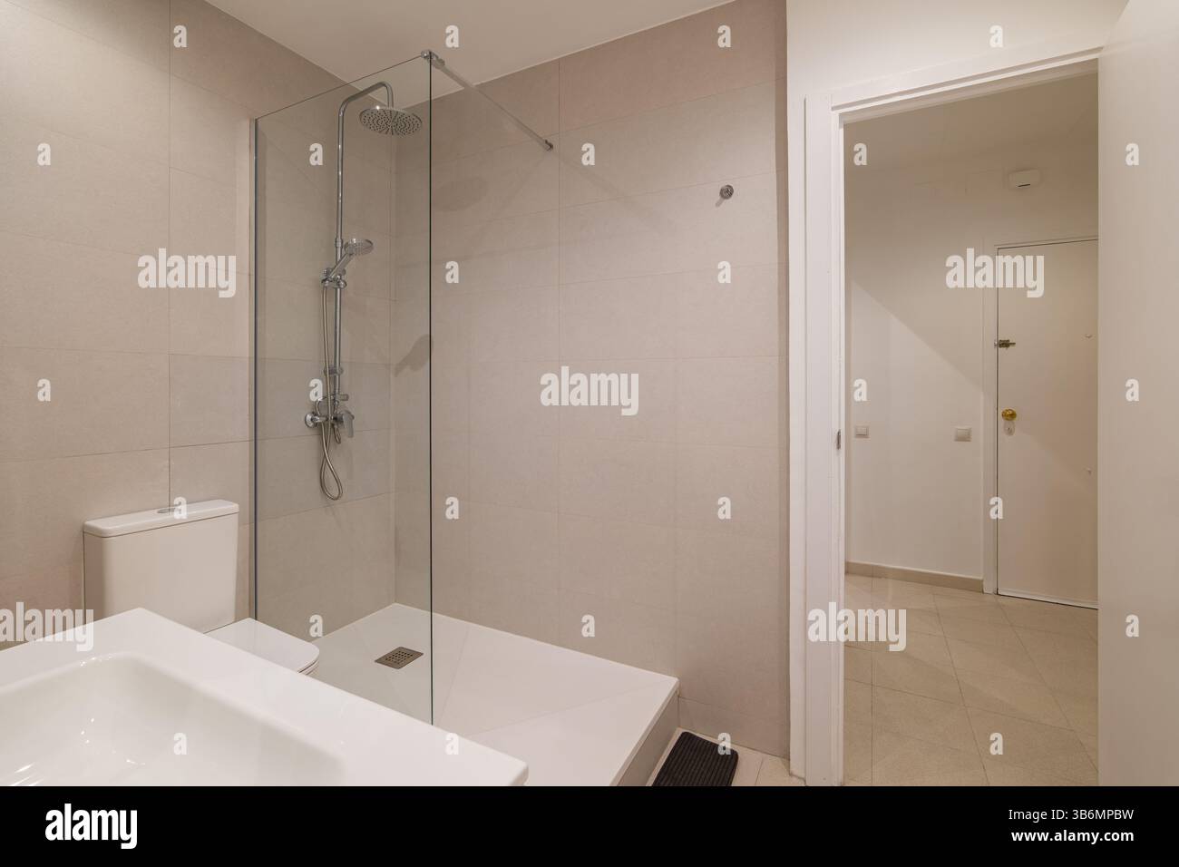 Modern minimalist bathroom with walk-in shower and neutral beige tiles ...