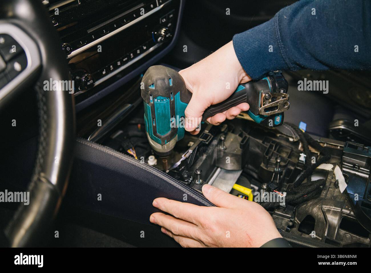 A master mechanic disassembles the car interior around the center ...