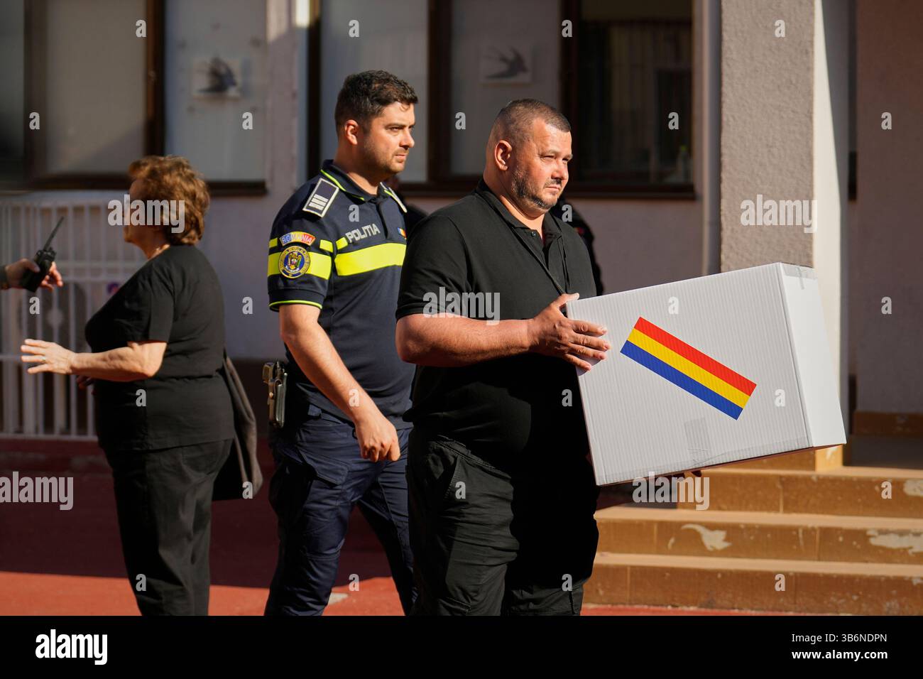 An election official carries a mobile ballot box outside a polling station during the first ...