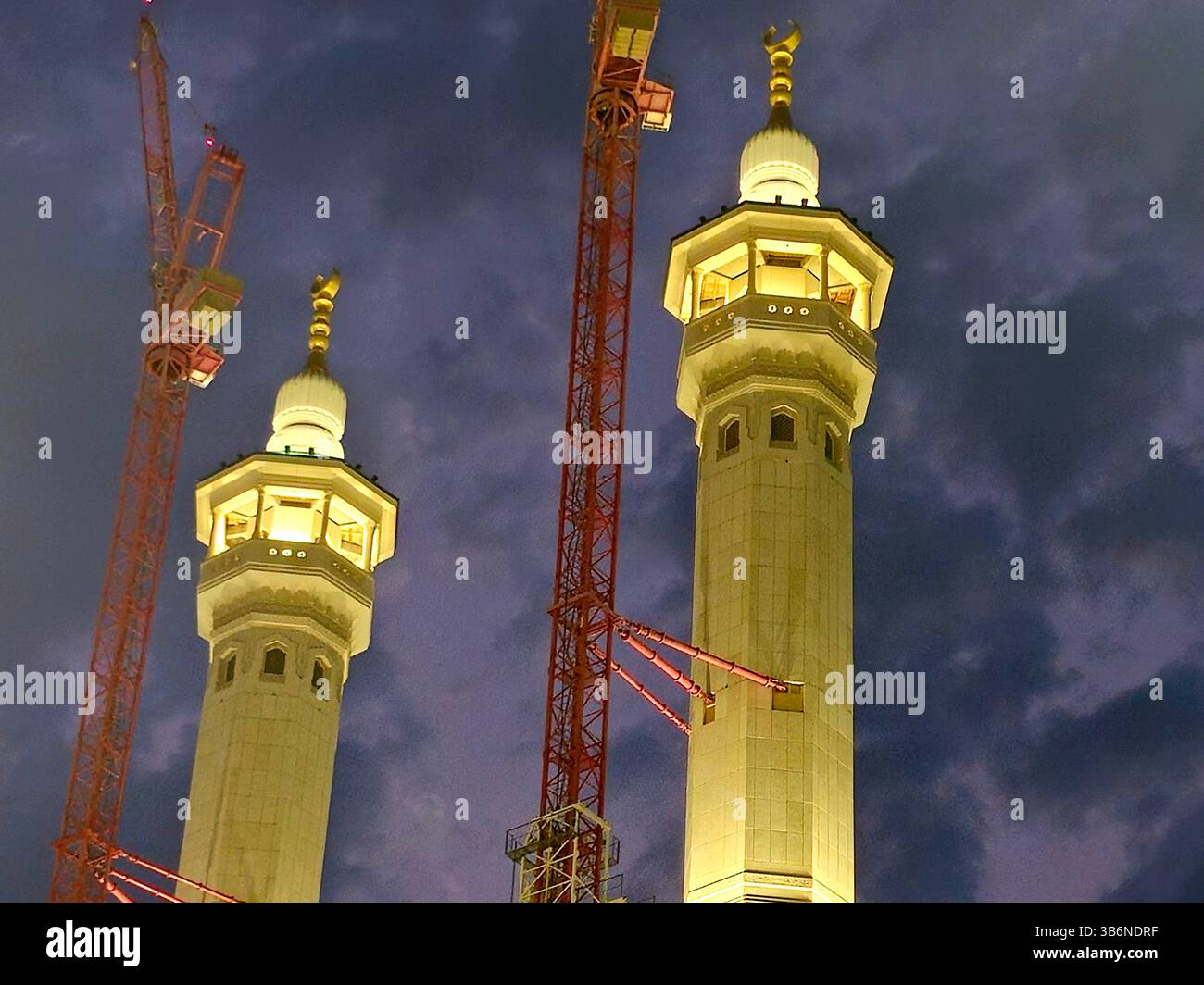 The minarets of the grand sacred mosque of Makkah with cranes, the most ...