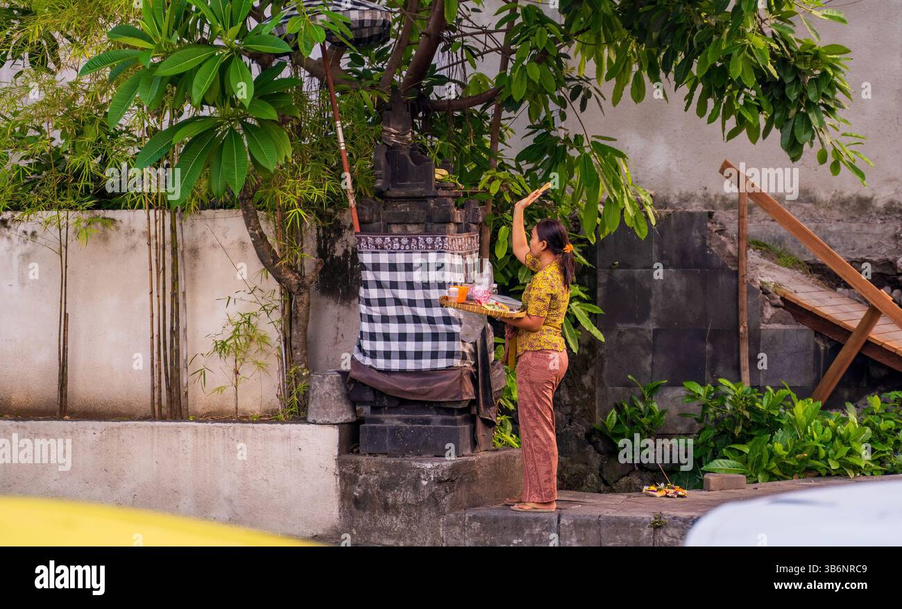 Bali, Indonesia - December 12, 2023: Woman in yellow offering prayers ...
