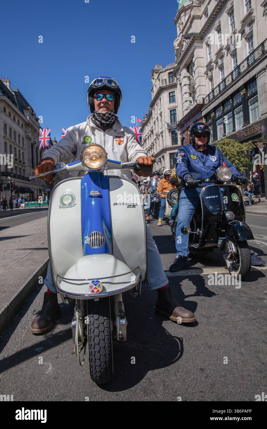 A Mod riding a classic scooter waits at a set of traffic lights on a ...