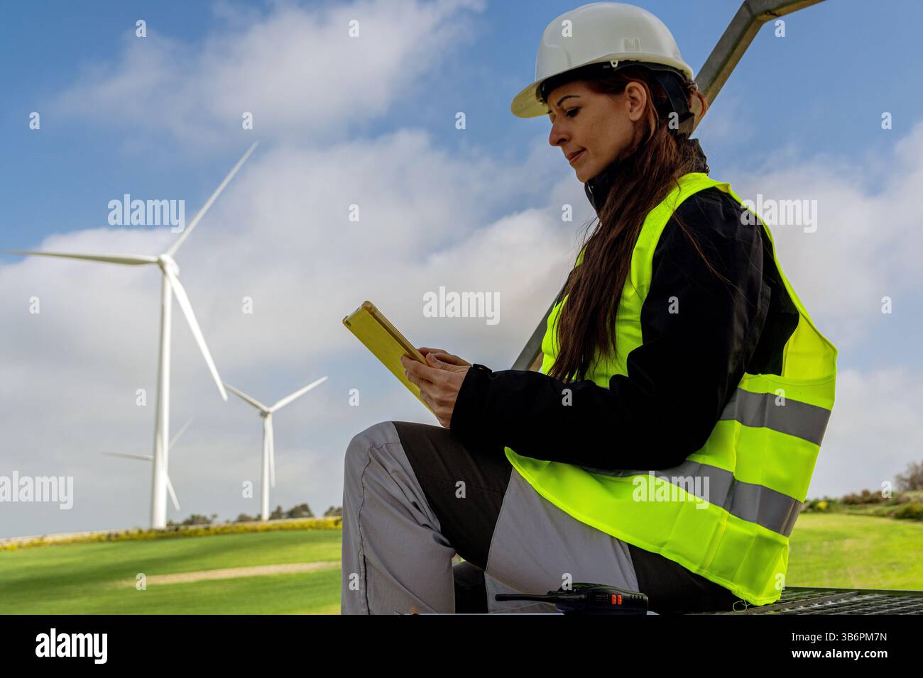Female engineer using digital tablet working in wind turbine power ...