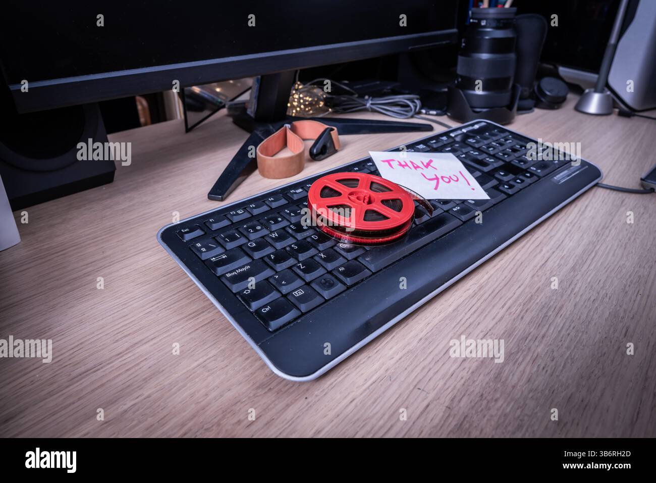Vintage film reel and thank you note sit on a computer keyboard ...