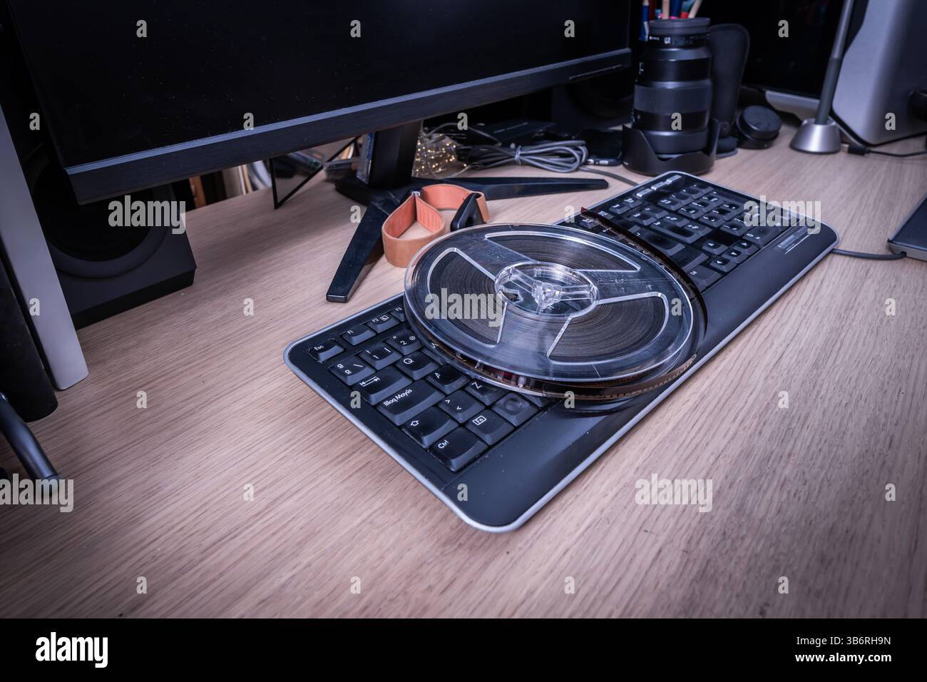 Vintage magnetic tape resting beside contemporary computer keyboard ...