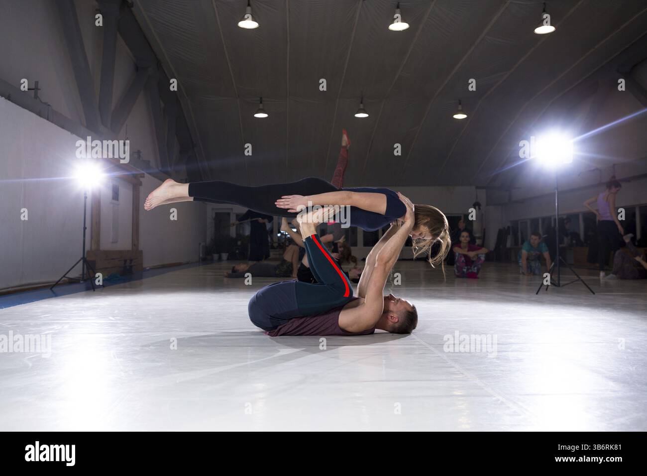 Couple does acroyoga, physical practice yoga and acrobatics. Balance ...