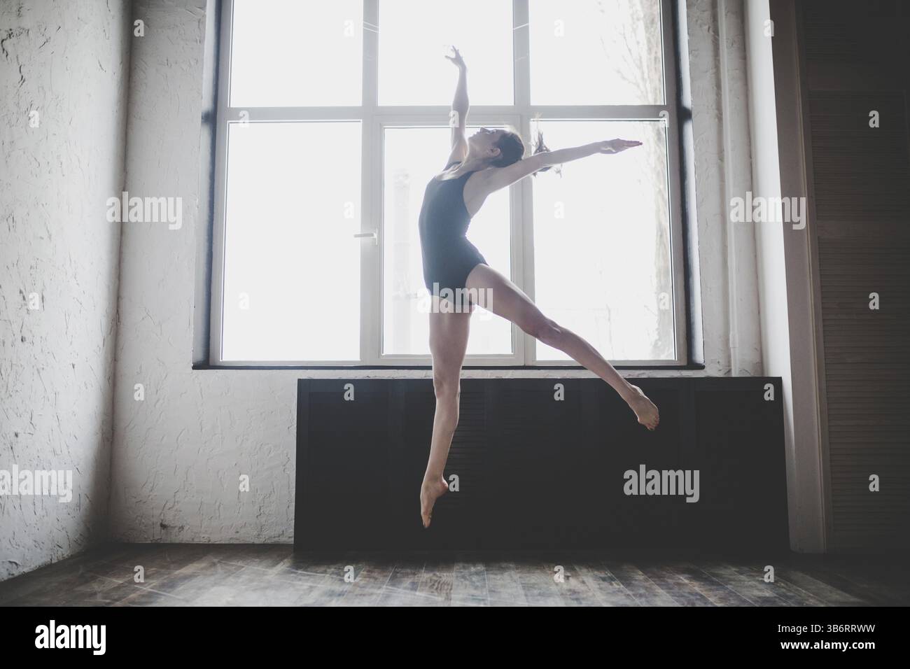 Plasticity slim woman dancing near window. Professional dancer enjoy ...