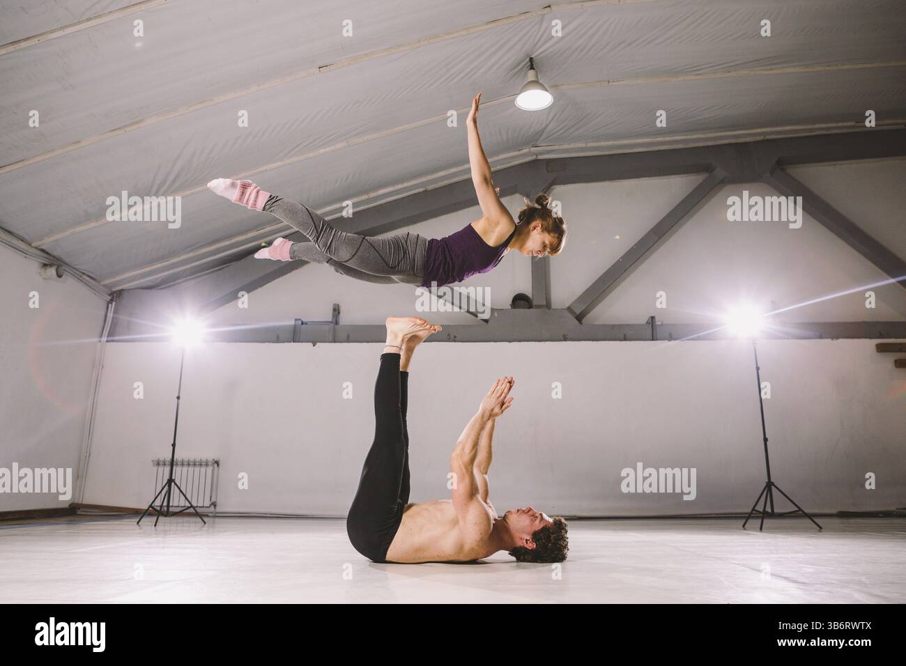 Young couple Couple practicing acro yoga in gym. Healthy lifestyle ...