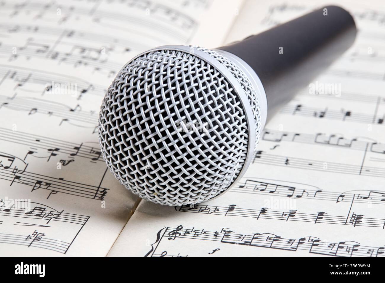 Microphone for vocal with silver metal head close up over music sheet ...