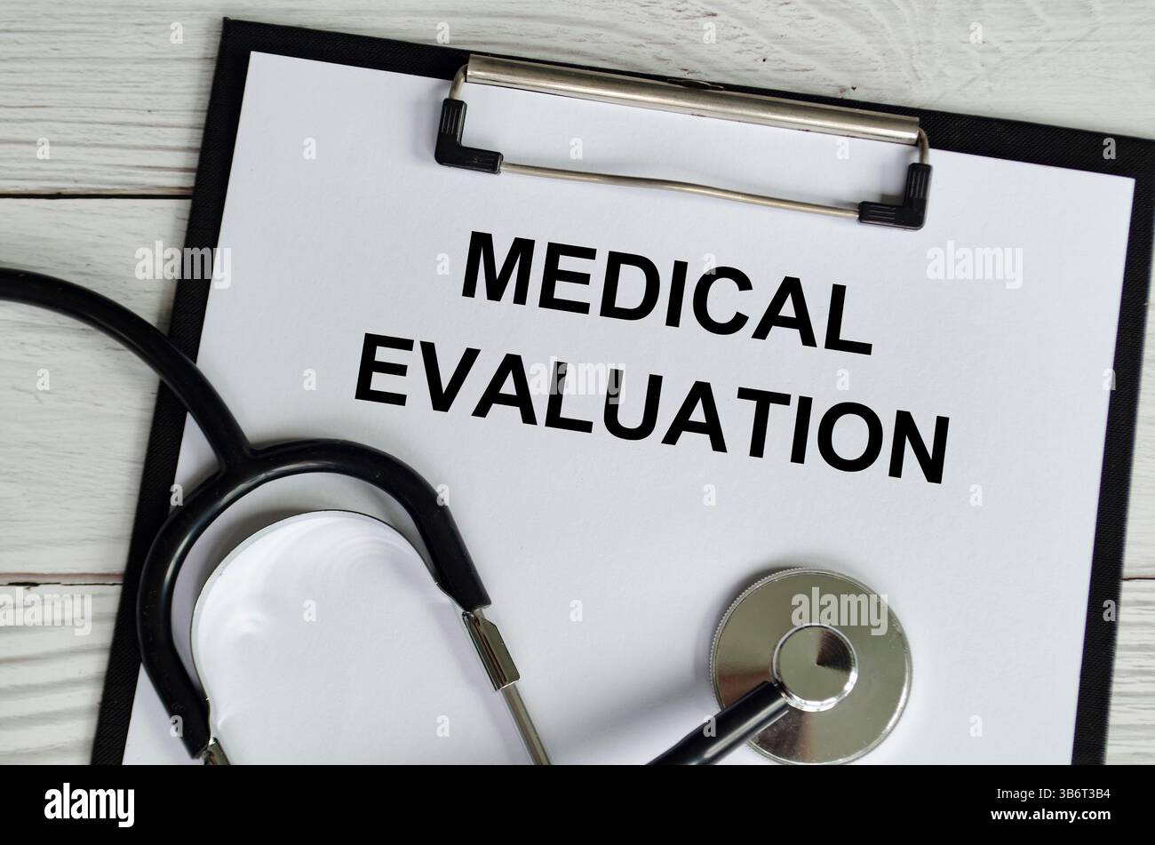 Top view of Medical Evaluation Text on white paper clipboard with ...
