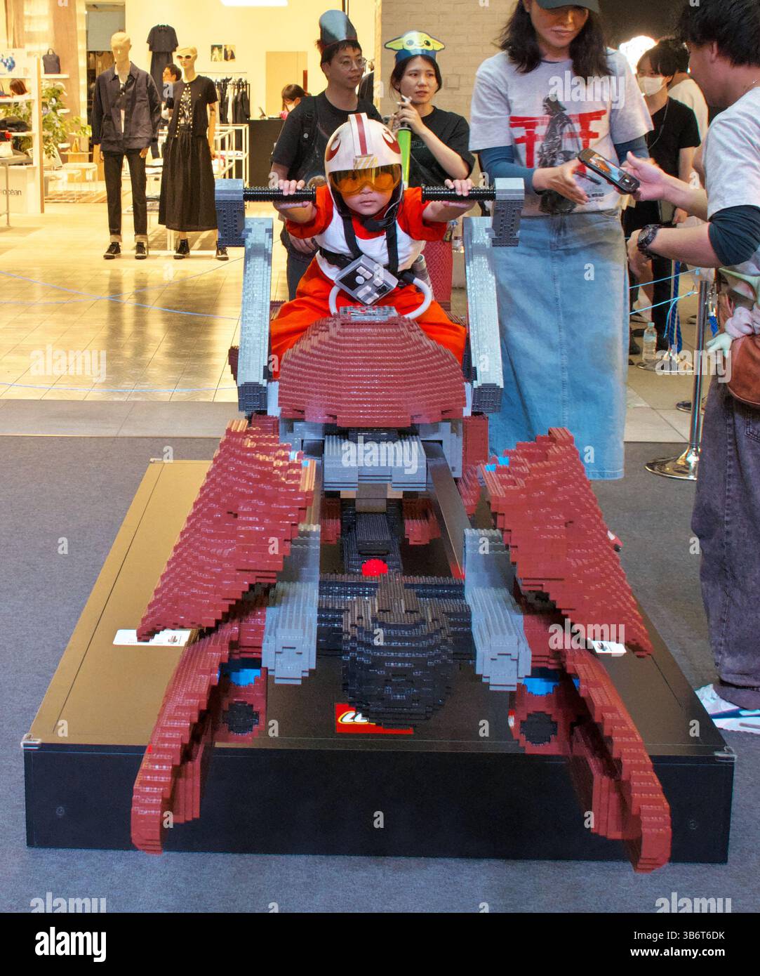 Yokohama, Japan. 04th May, 2025. A child poses for camera with Lego bricks Speeder Bike during ...