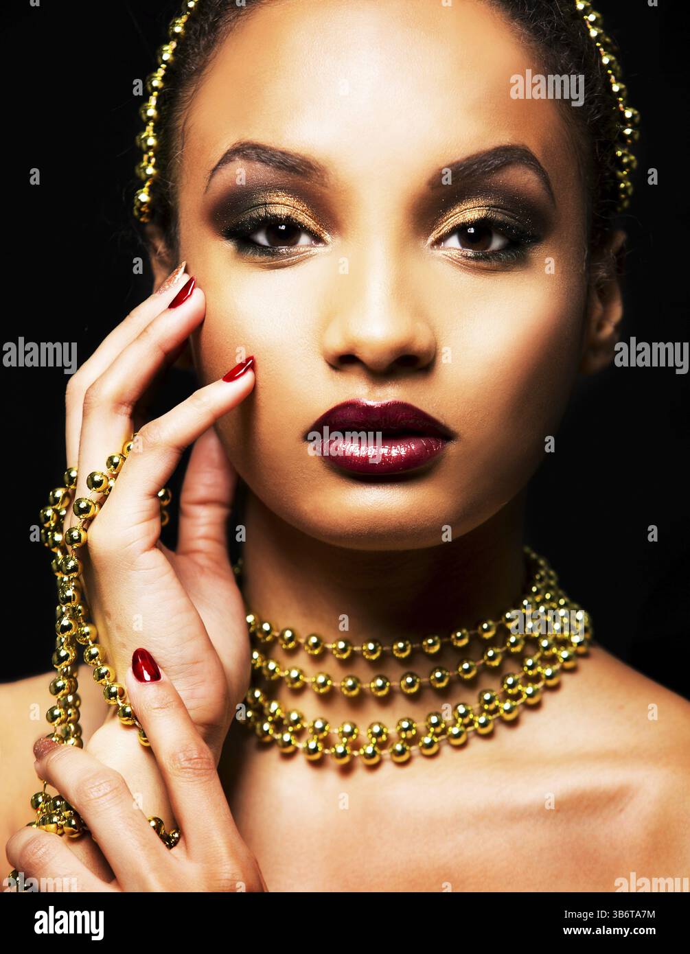 Upscale Indian woman wearing gold jewellery and red lipstick on black ...