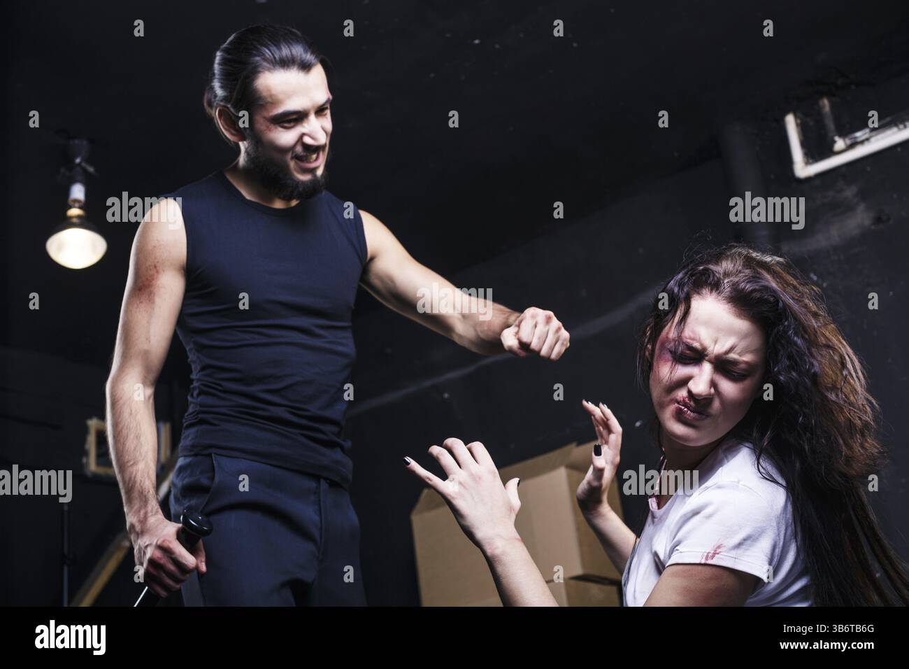 Man beating up his wife on black background Stock Photo - Alamy