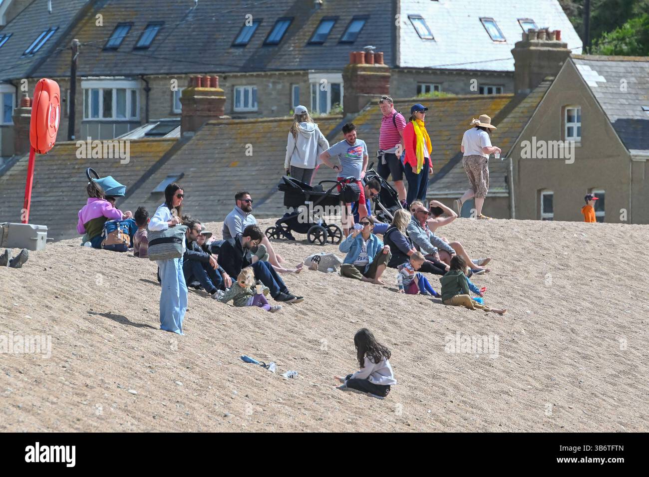 West Bay, Dorset, UK. 4th May 2025. UK Weather. Beachgoers enjoying the ...