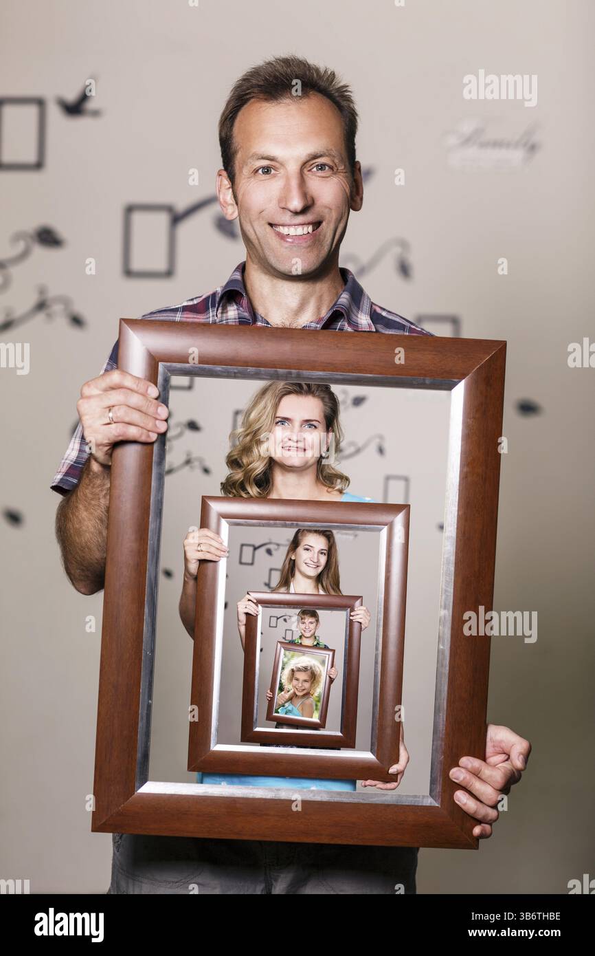 Happy father holding portrait with his family each is located inside ...