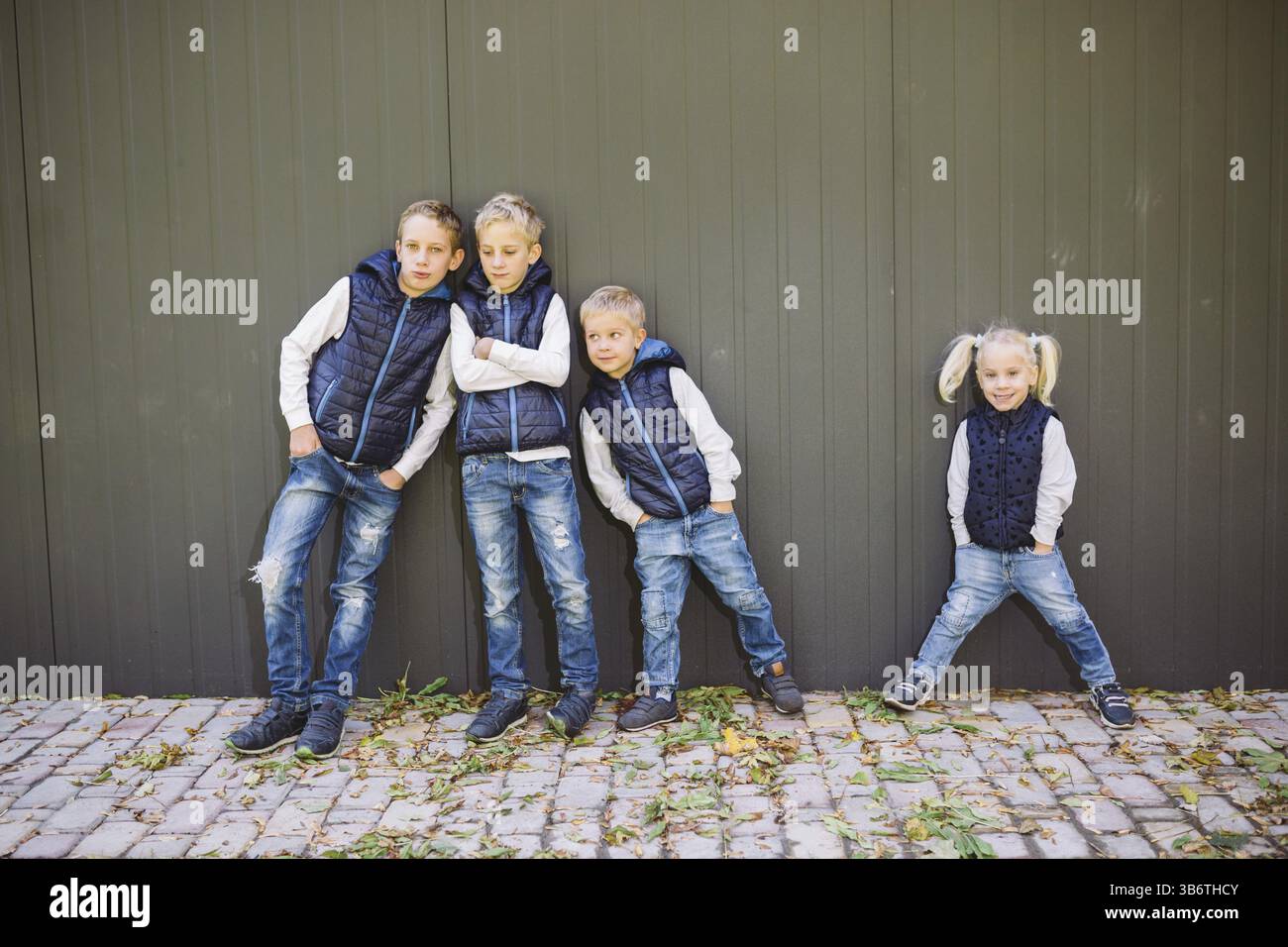 Funny Caucasian big family of three brothers and sister posing standing ...