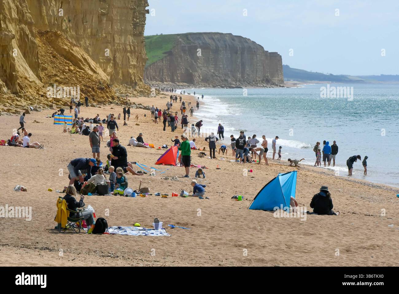 West Bay, Dorset, UK. 4th May 2025. UK Weather. Beachgoers enjoying the ...