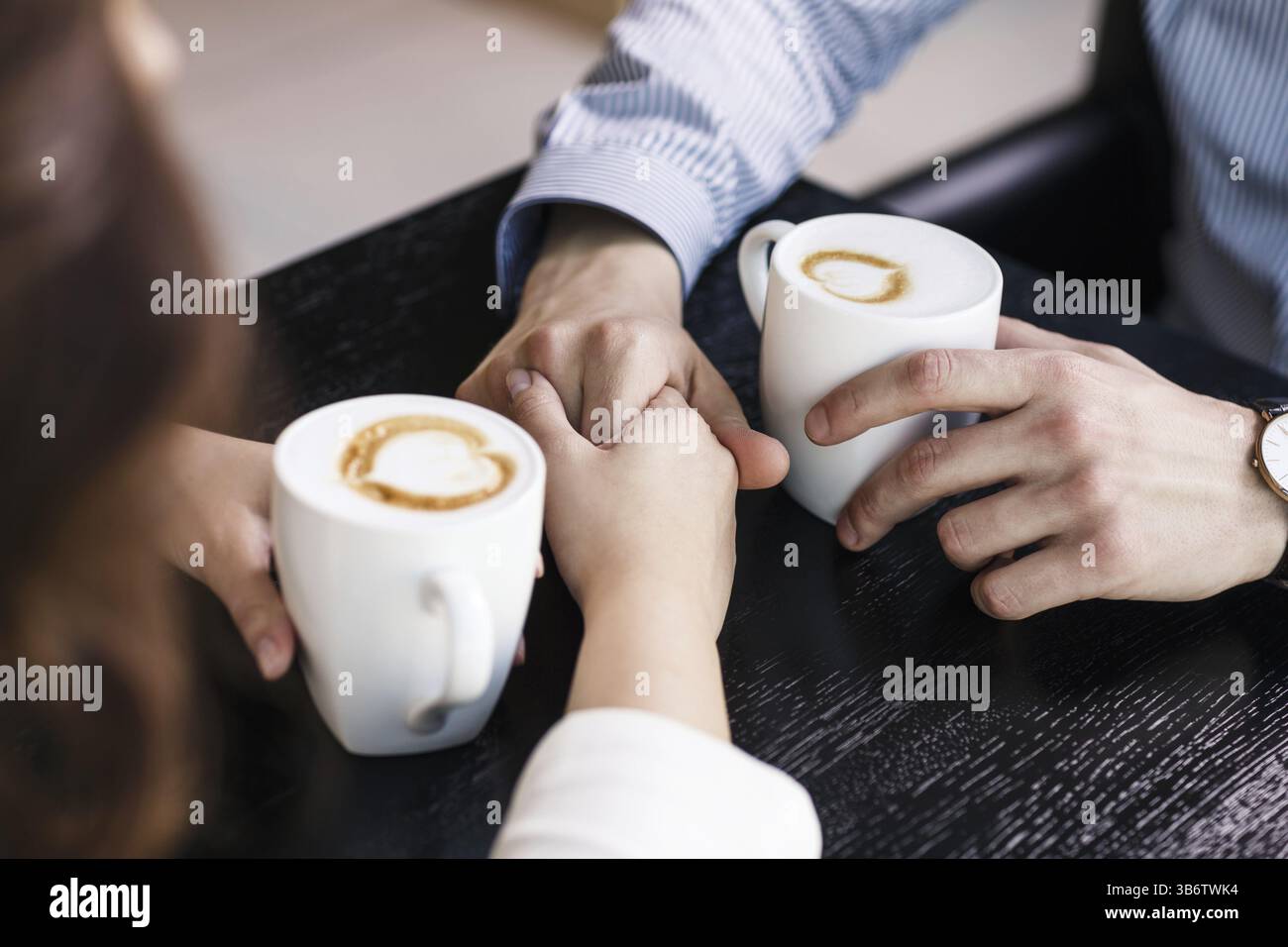 Hands on the table holding cups of coffee Stock Photo - Alamy