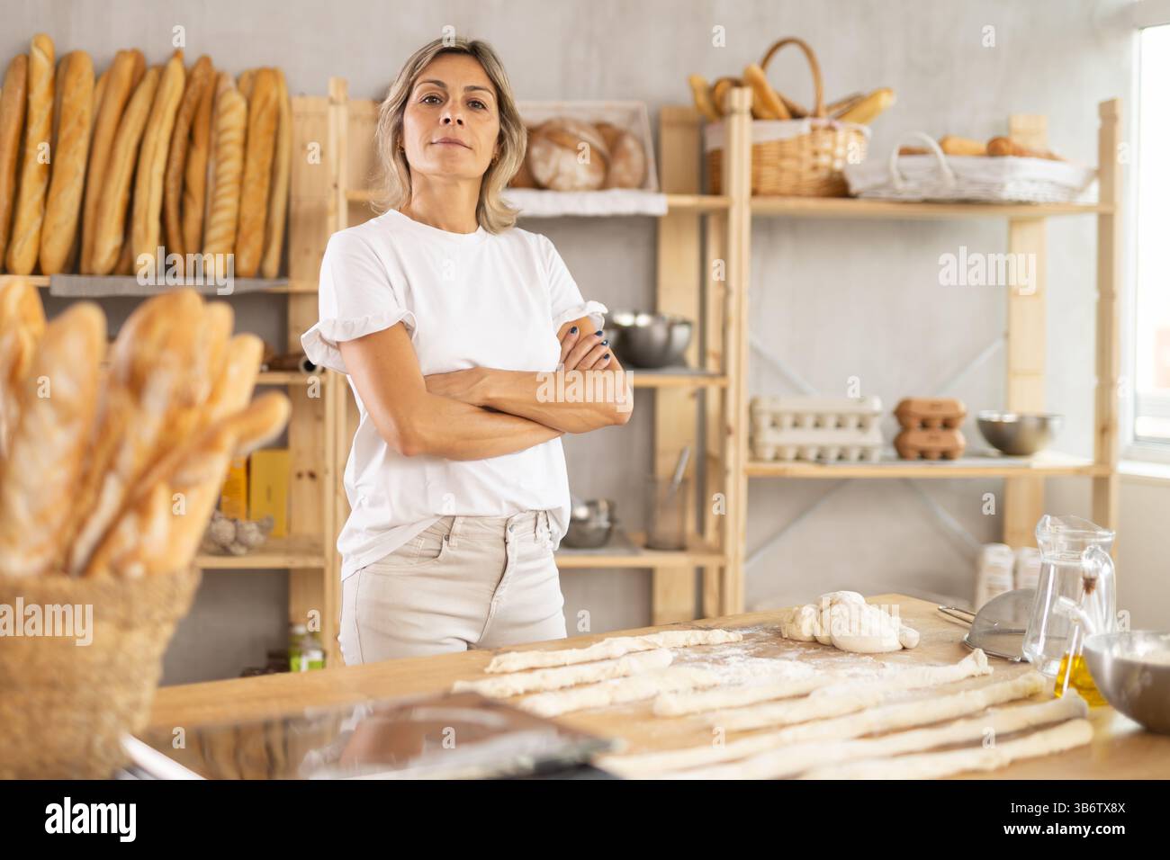 Elderly woman baker posing in bakery Stock Photo - Alamy