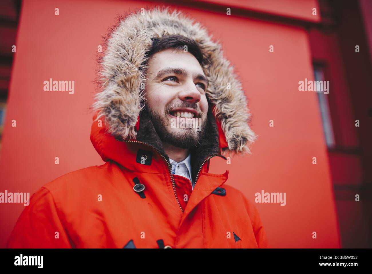 Portrait of a young handsome guy, a student with a beard in a red ...