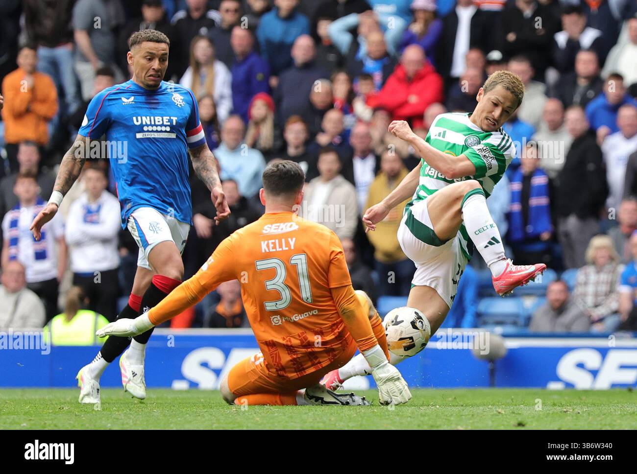 Rangers goalkeeper Liam Kelly makes a save from Celtic's Daizen Maeda ...