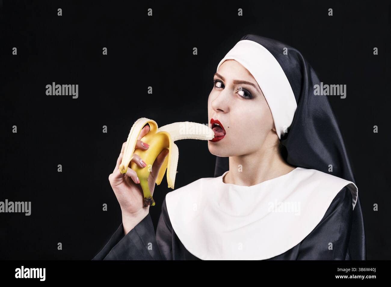 Young nun in religious concept eat banana Stock Photo - Alamy