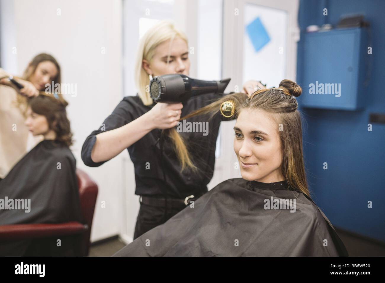 Portrait of happy woman at the hair salon. Professional hair styling ...