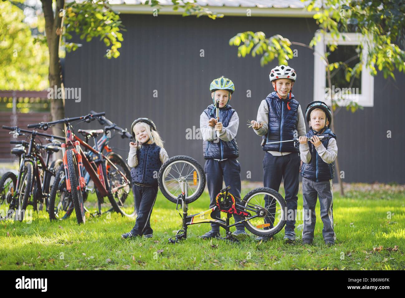 Children mechanics, bicycle repair. Happy kids fixing bike together ...