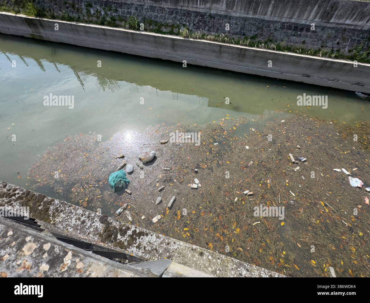 Plastic pollution accumulating in a shallow river, highlighting ...