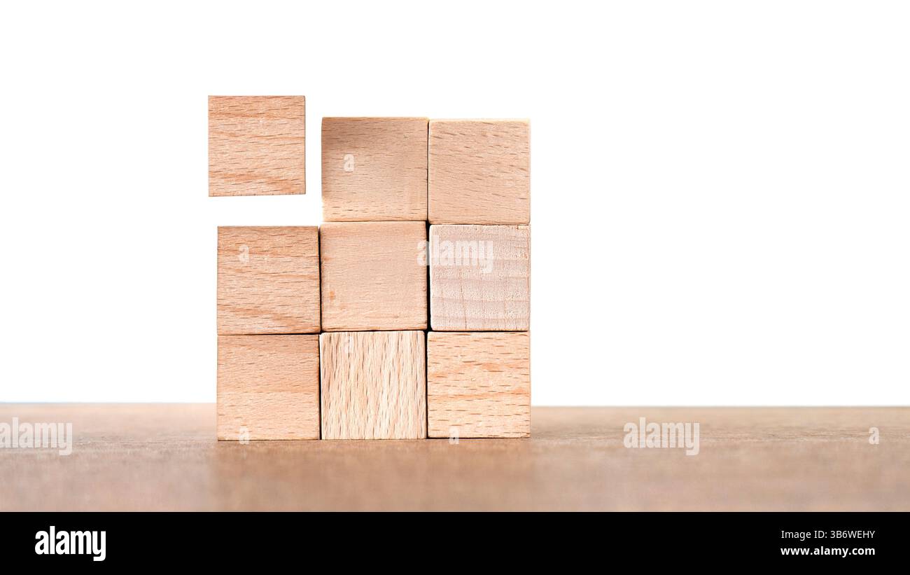 Wooden blocks arranged neatly on a table surface, with one block ...