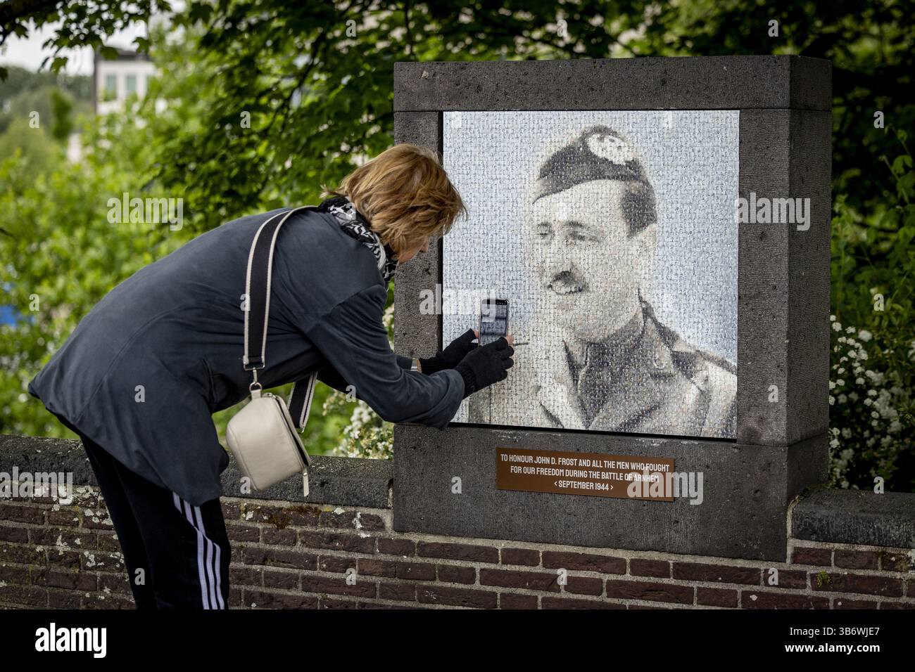ARNHEM - People look at the new plaque on the monument at the John ...