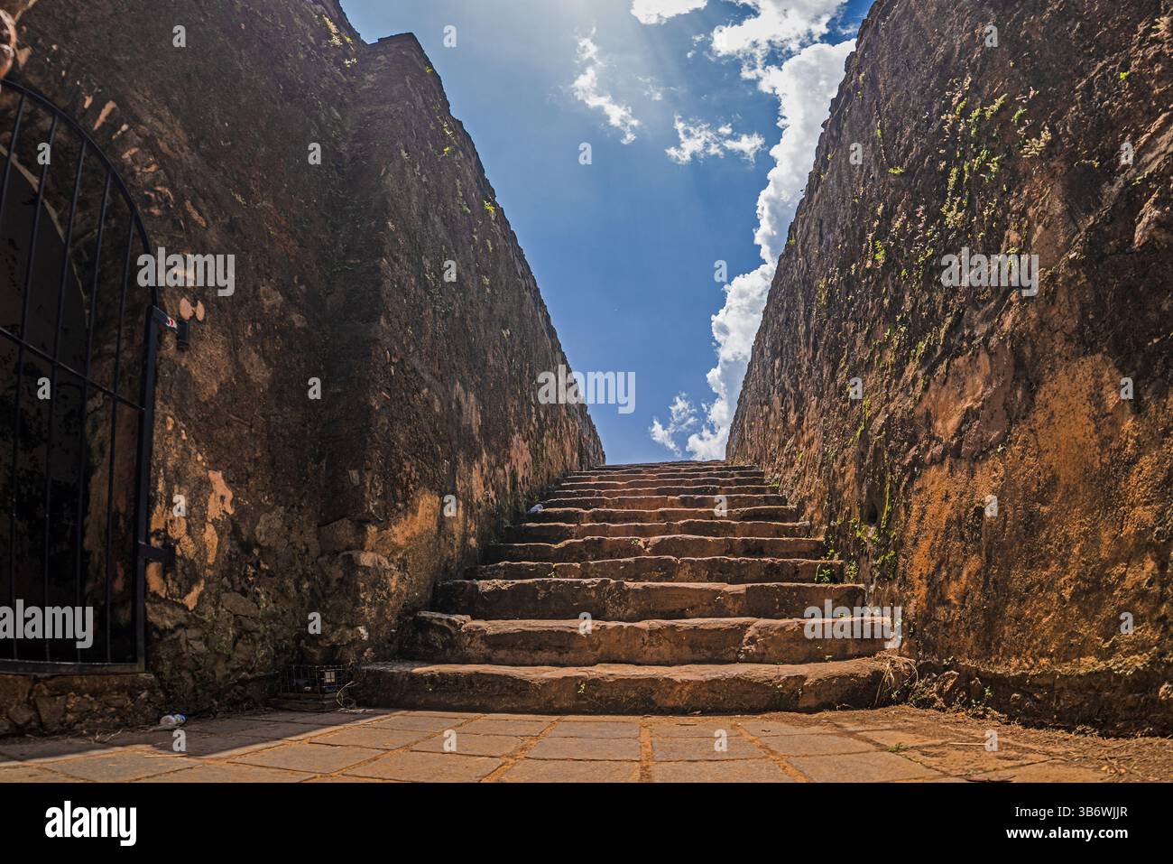 Stone staircase under archway in Galle Fort leading to blue sky and ...