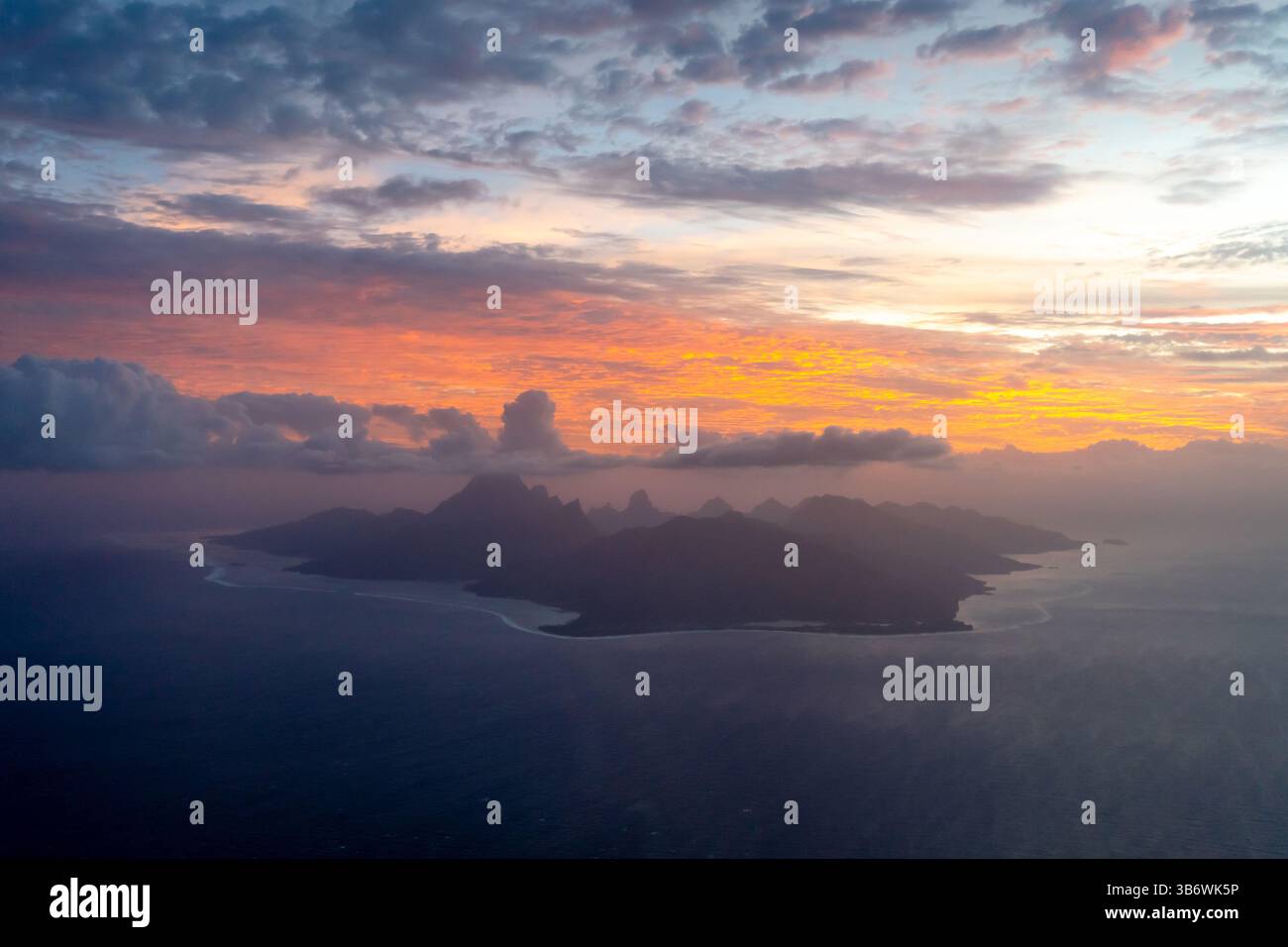 Moorea island, seen from above during sunset, reveals its rugged peaks ...