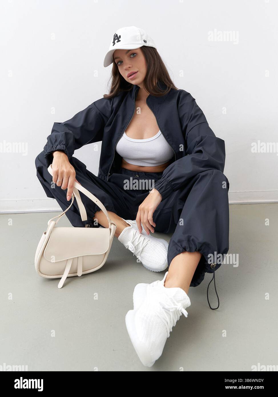Trendy female model poses stylishly in a modern studio setting during a ...
