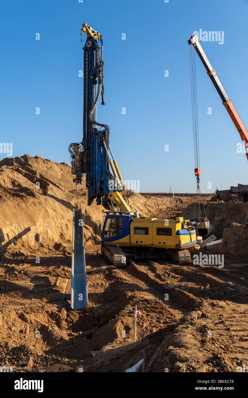 The yellow hydraulic piling machine lays Larsen dowels after extraction ...