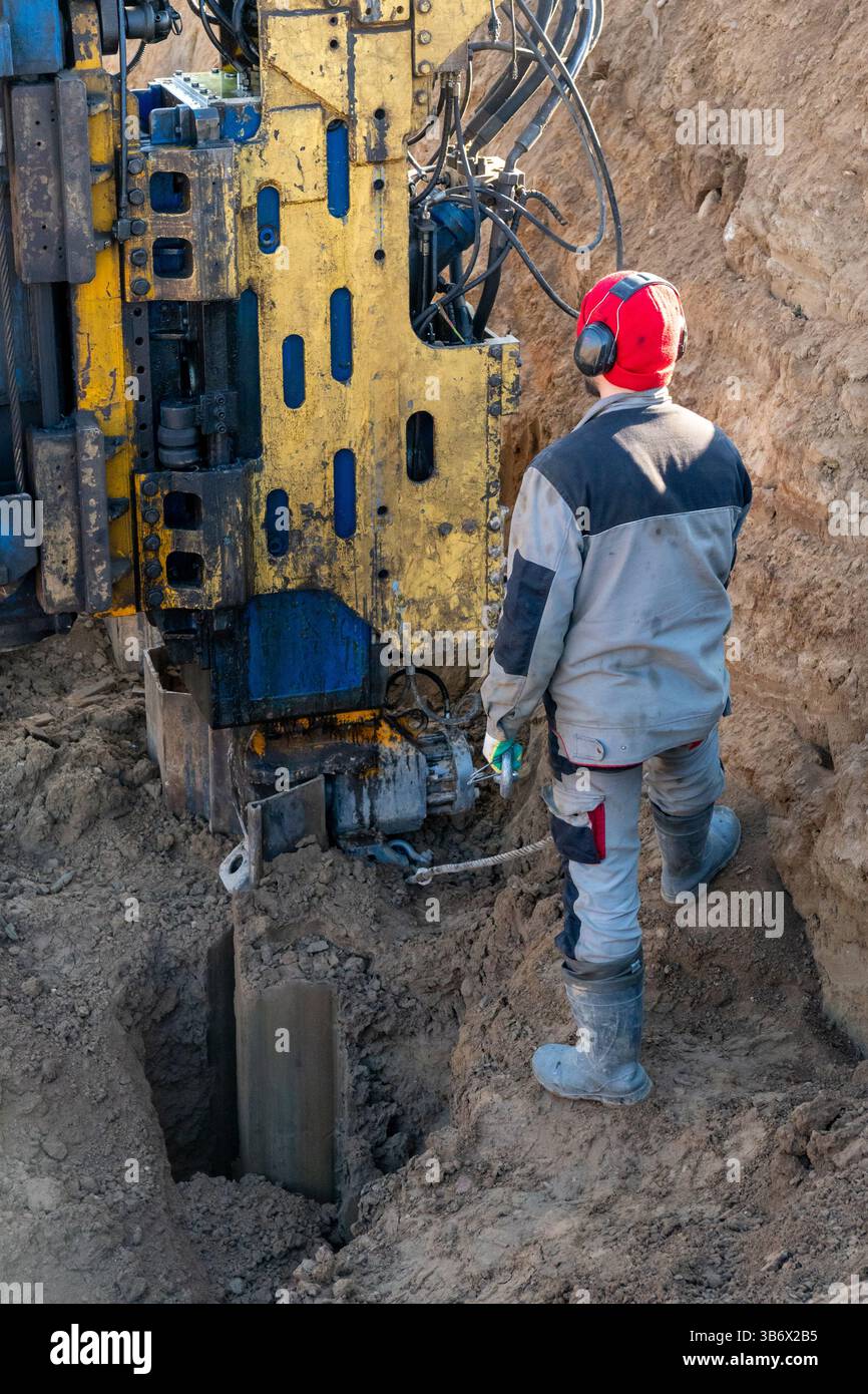 A worker controls the extraction of Larssen sheet piling from the ...