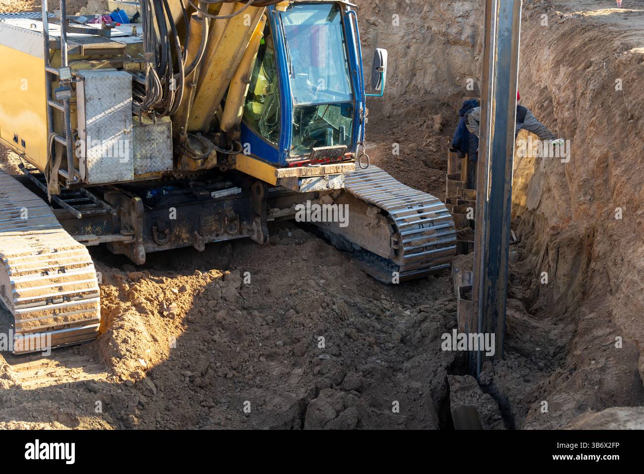 The yellow hydraulic piling machine lays Larsen dowels after extraction ...