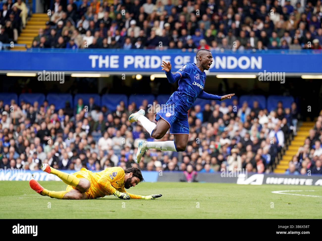 Liverpool goalkeeper Alisson Becker (left) tackles Chelsea's Nicolas ...