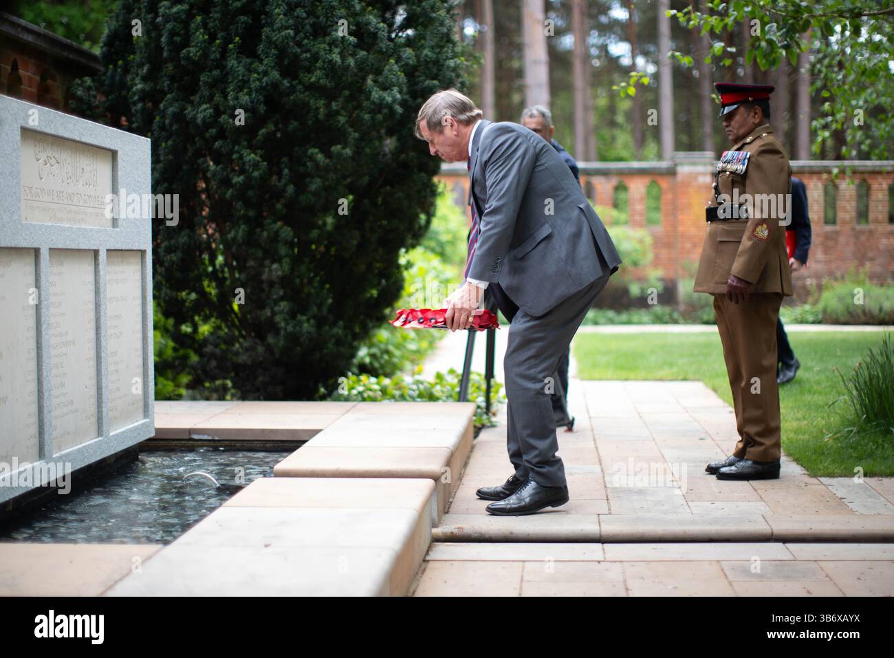 A person lays a wreath in the Peace Garden, Woking, ahead of a VE Day ...