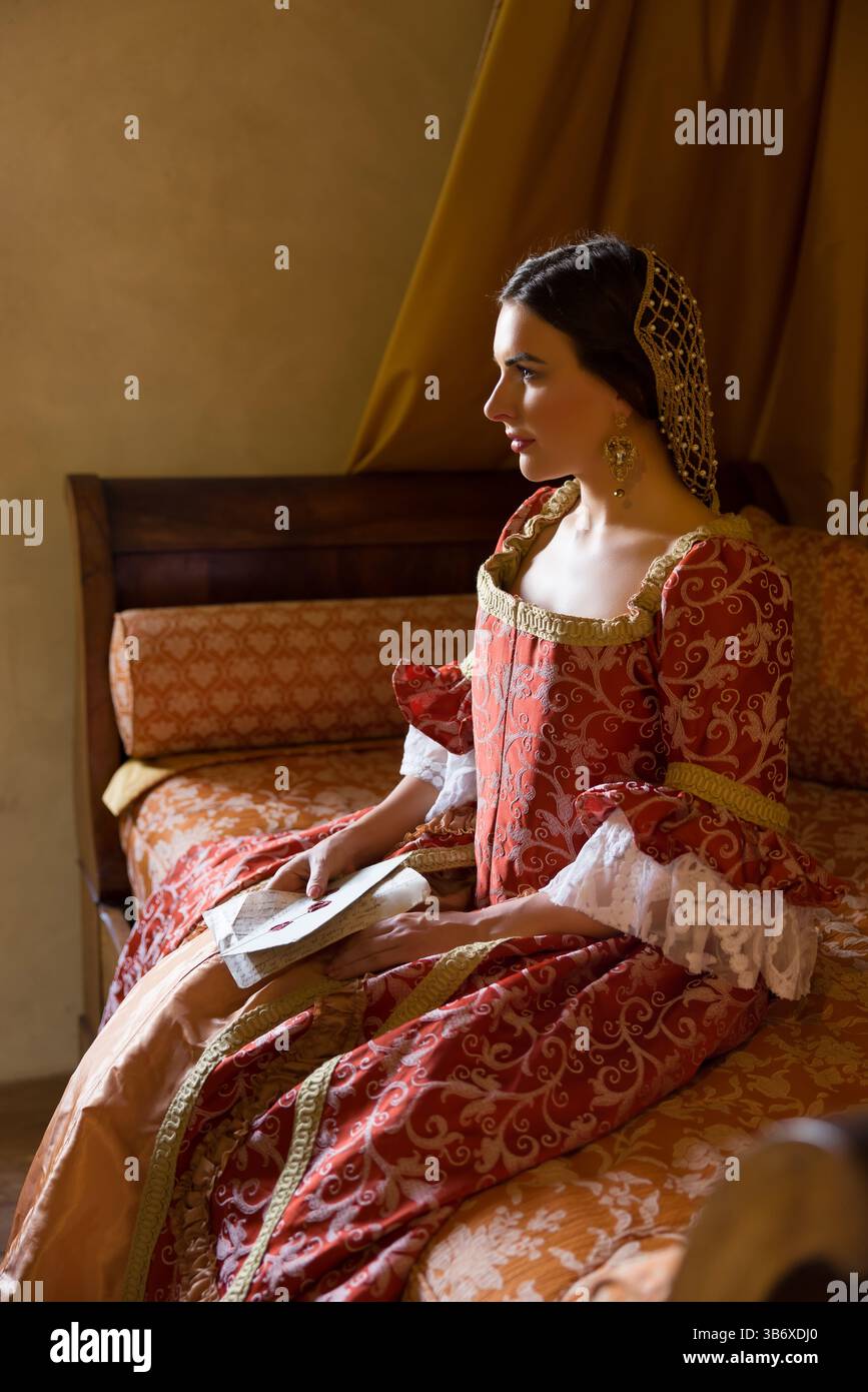 Renaissance lady in late medieval gown sitting on a beautiful canopy ...