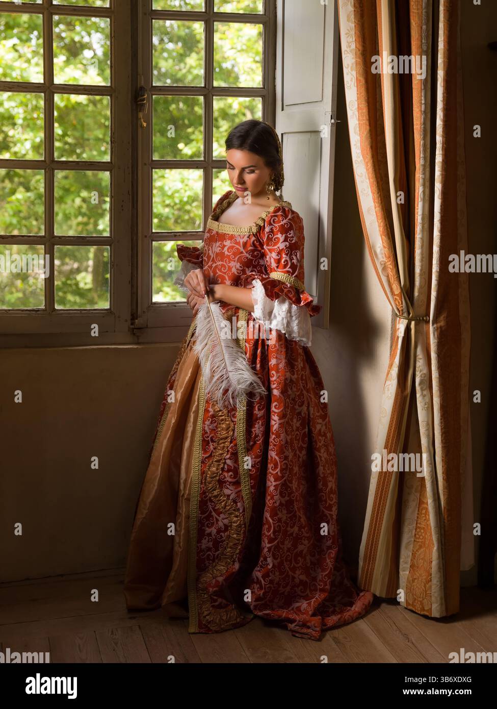 Woman wearing authentic Renaissance costome and headdress standing at ...
