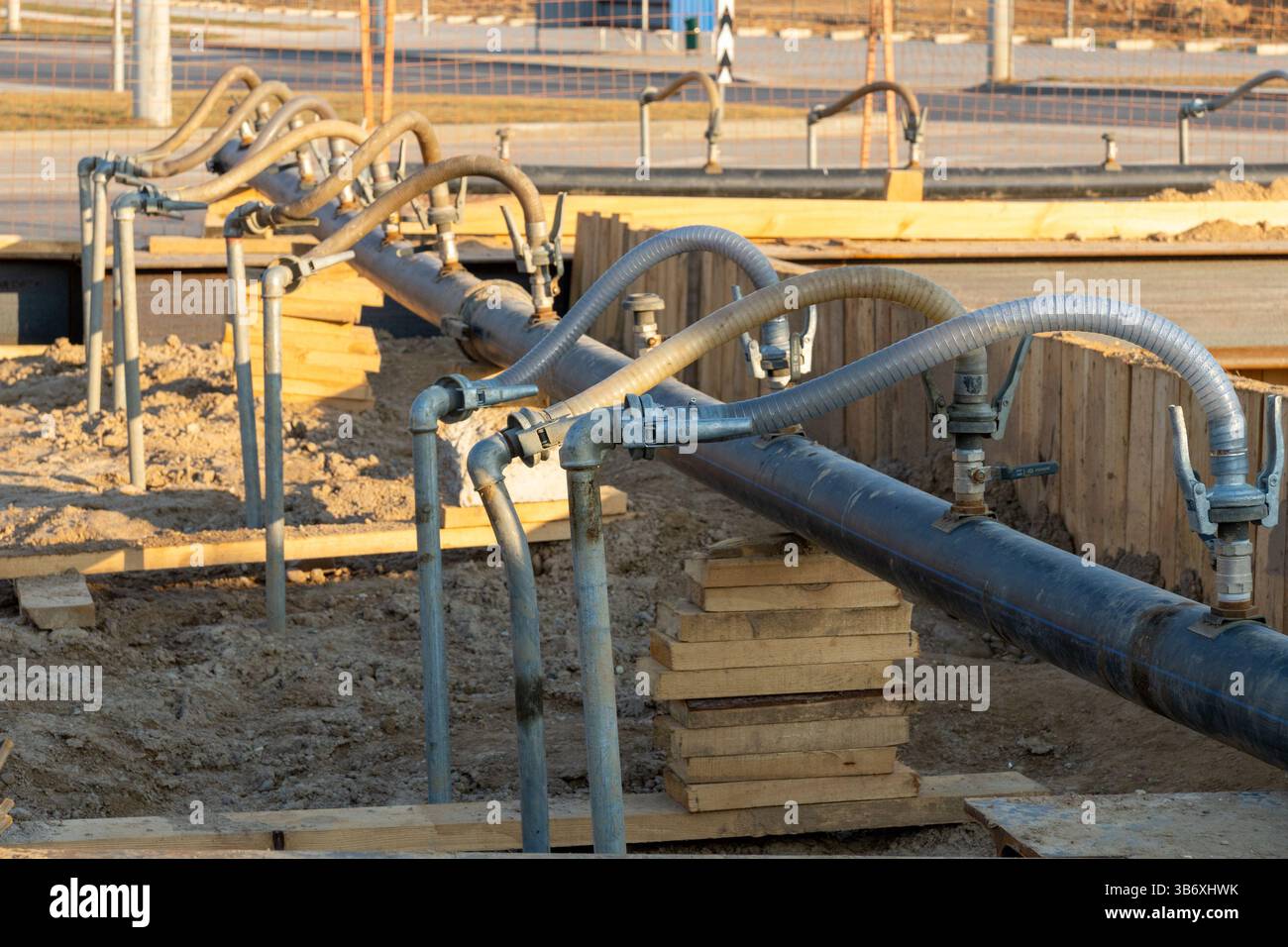 A close-up view of a series of flexible hoses connected to a pipe at a ...