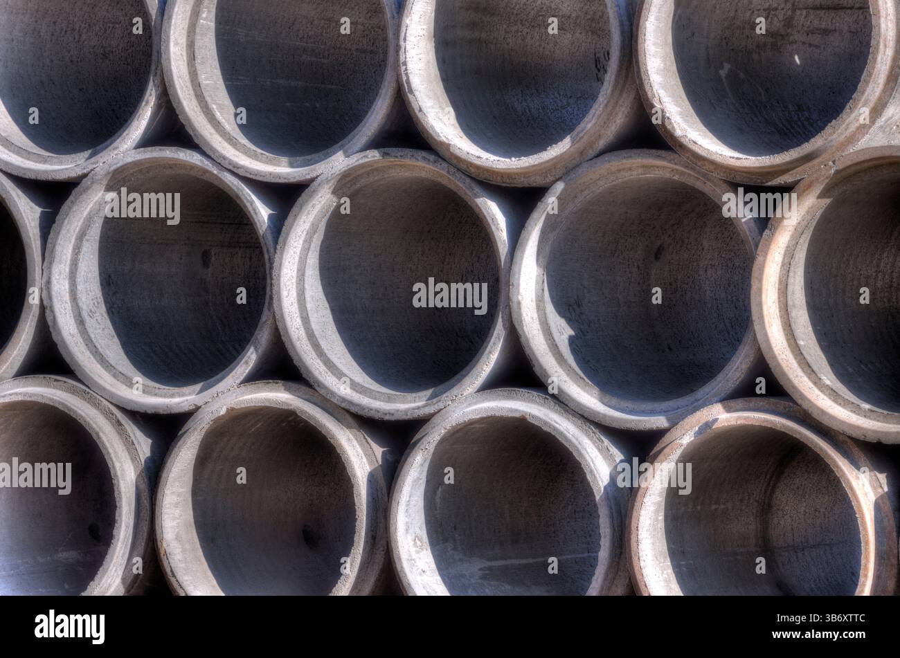 Concrete pipe conduit stacked on a construction site awaiting ...