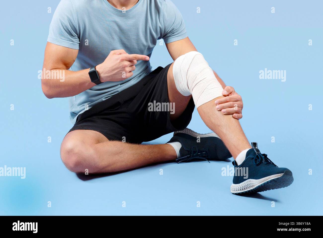 Athletic millennial man having sports injury, pointing at his sprained ...
