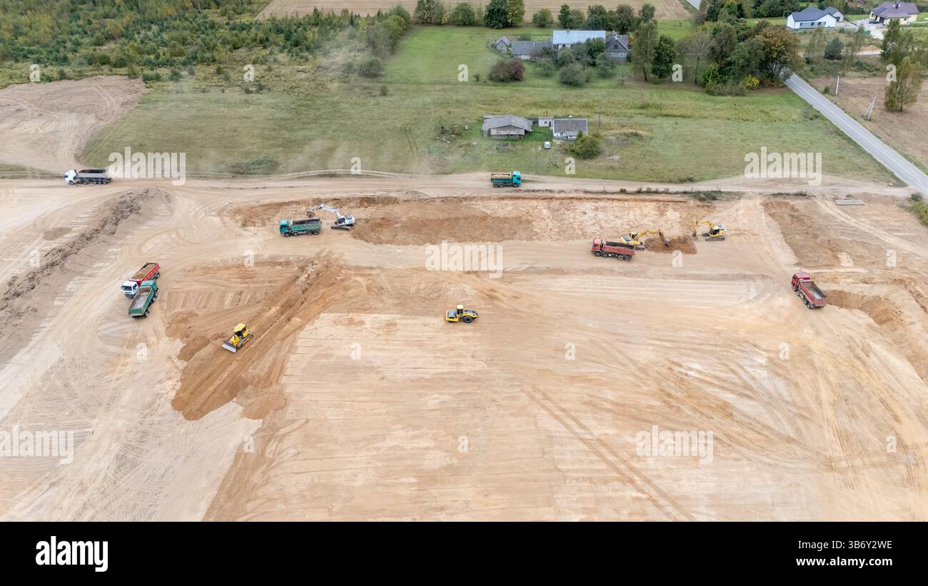 Aerial view of a construction site with heavy machinery working on land ...