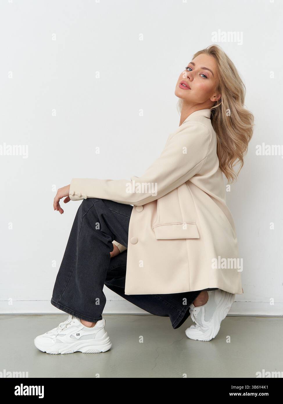 Elegant woman poses in a modern studio, showcasing contemporary fashion ...