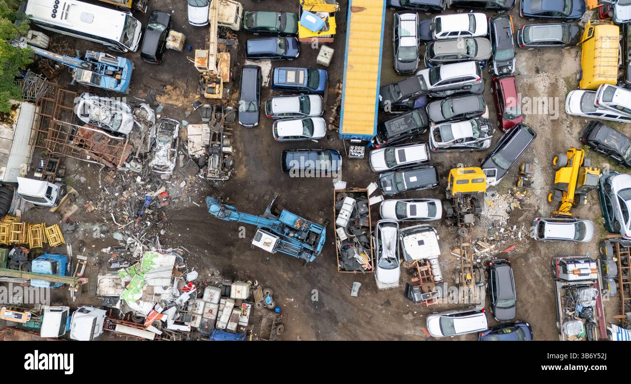 Aerial view of a cluttered junkyard with various vehicles and machinery ...