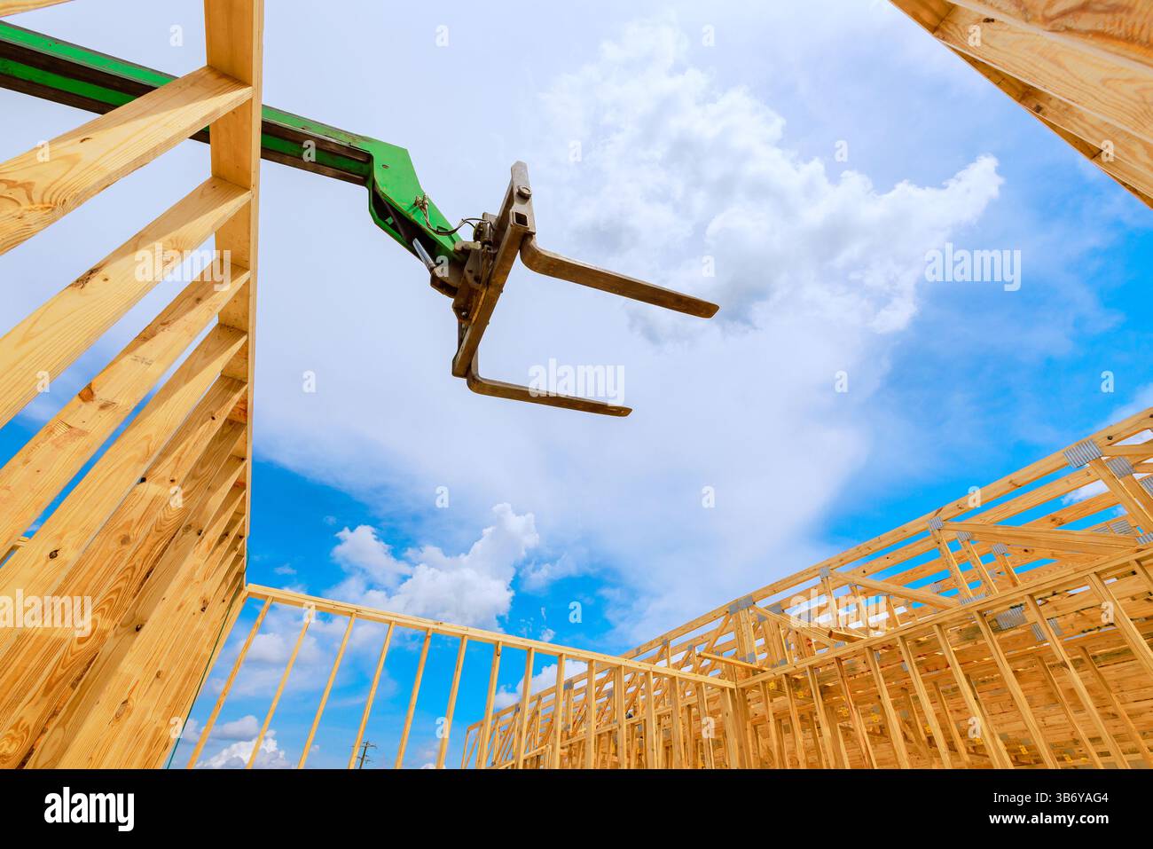 Workers are assembling structure with telehandler crane lifting wooden ...