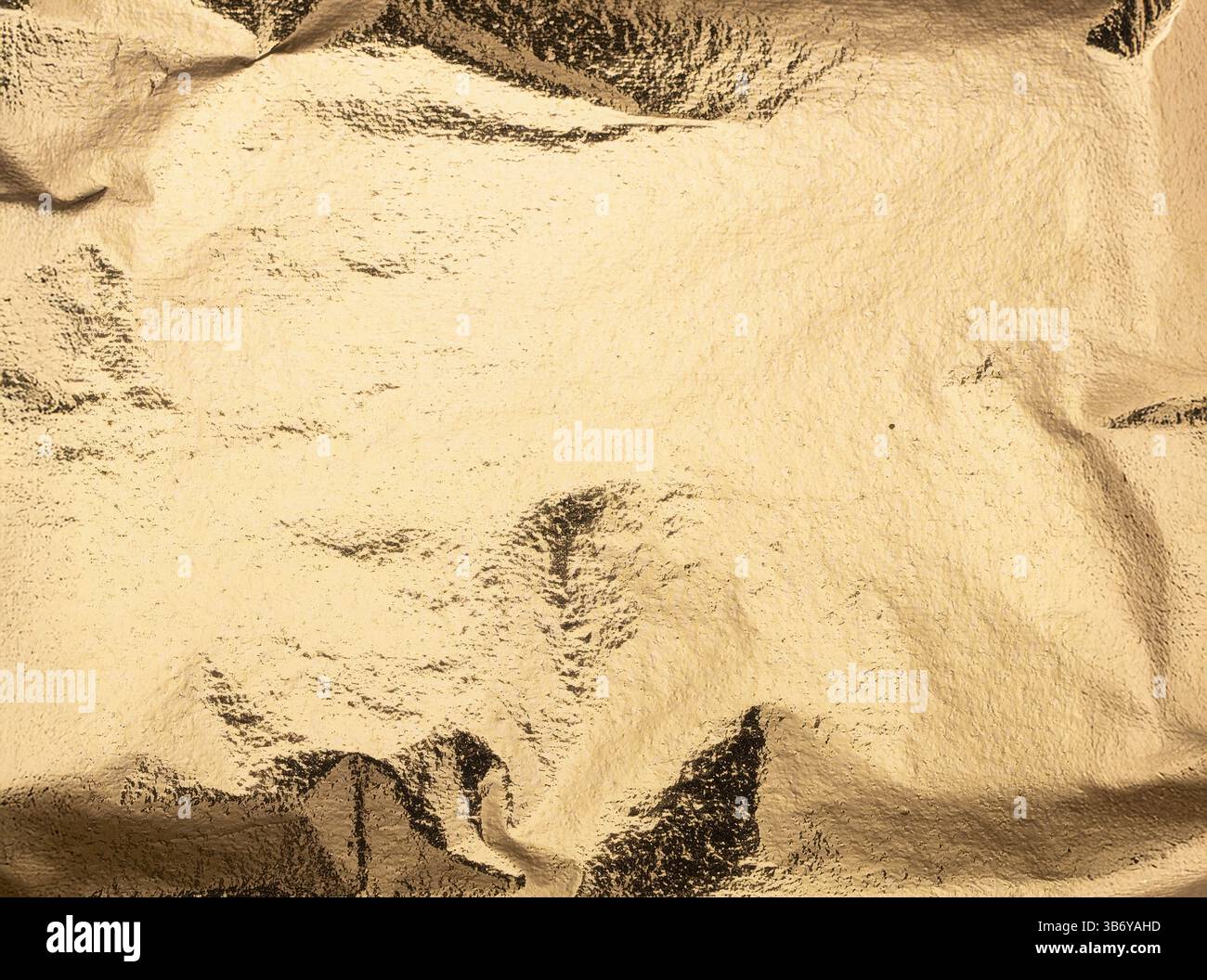 Smooth yet subtly crinkled sheet of shiny gold foil paper with ...